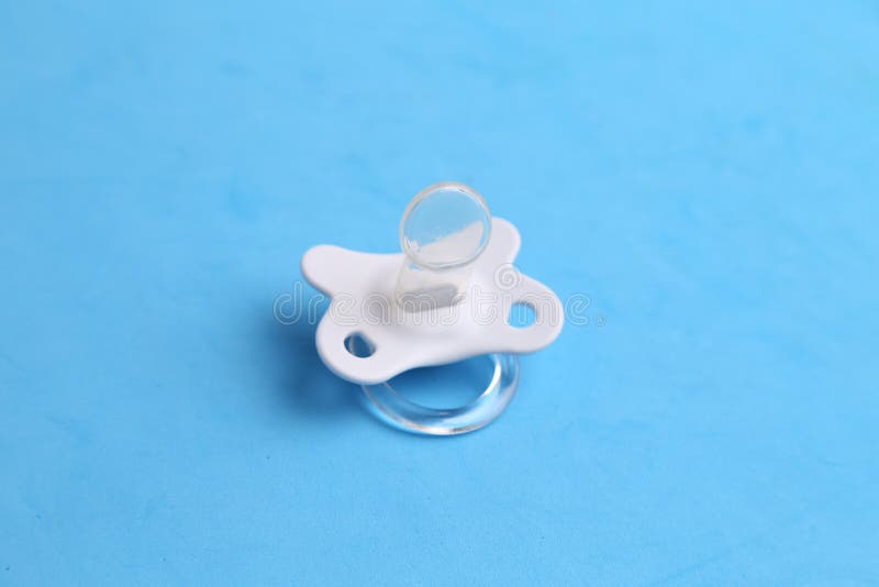 Closeup of a White Pacifier Isolated on a Blue Background Stock Image ...
