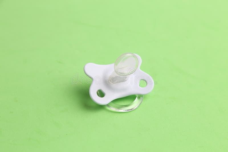 Closeup of a White Pacifier Isolated on a Green Background Stock Image ...
