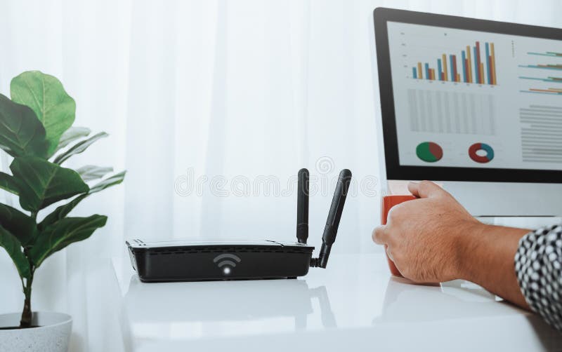 Closeup of a Wireless Router and a Man Using Computer on Living Room at ...