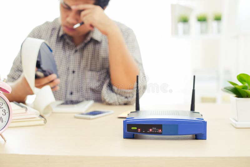 Closeup of a Wireless Router and a Man Using Computer on Living Room at ...