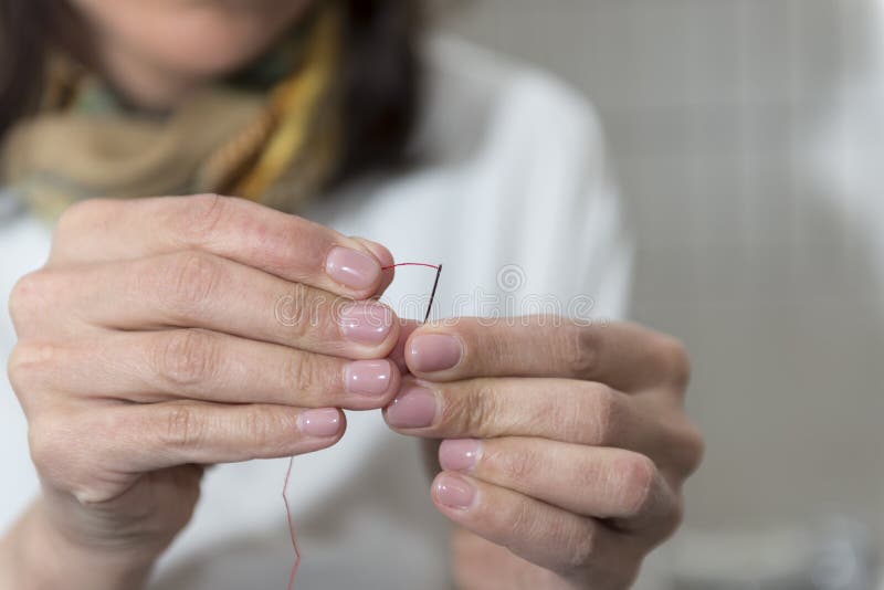 Closeup of a Woman Threading a Needle with a Red Thread Stock Image ...