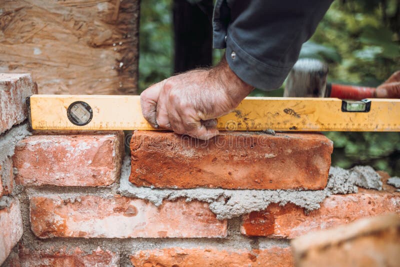 Closeup of Construction Worker Installing Bricks Using Level, Building ...