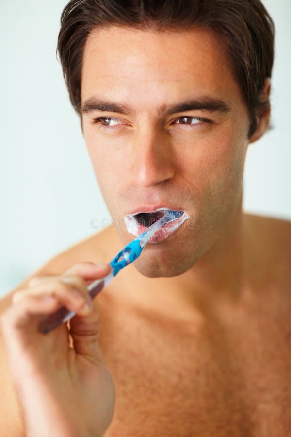 Closeup of a Young Thoughtful Man Brushing His Teeth. Closeup Portrait ...