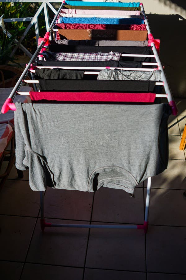 Clothes drying on a rack stock photo. Image of hanger - 268047094