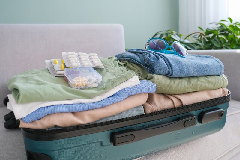 Clothes and Pills in a Travel Bag. Concept of Medication Required in ...