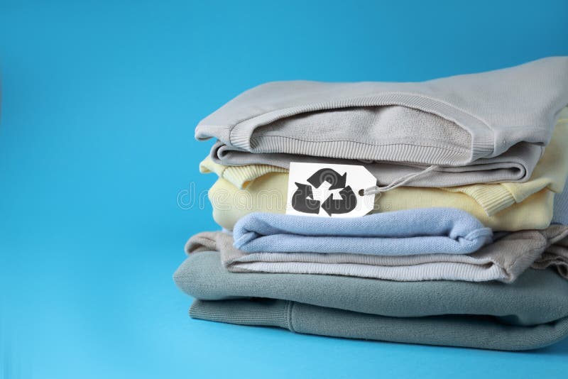 Clothes with Recycling Label on Light Blue Background, Space for Text ...