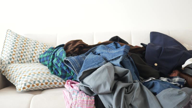 Sorting through a Pile of Mixed Laundry on a Cozy Sofa at Home Stock ...