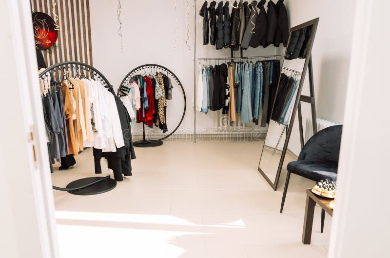 Clothes Store with Racks of Clothes and a Large Mirror Stock Image ...