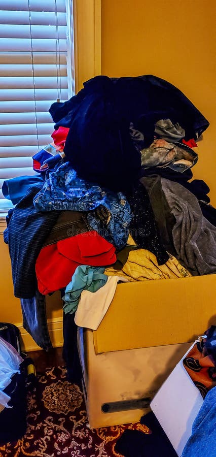 Clothes Thrown Haphazardly Mounded Up on Moving Box by Window Stock ...