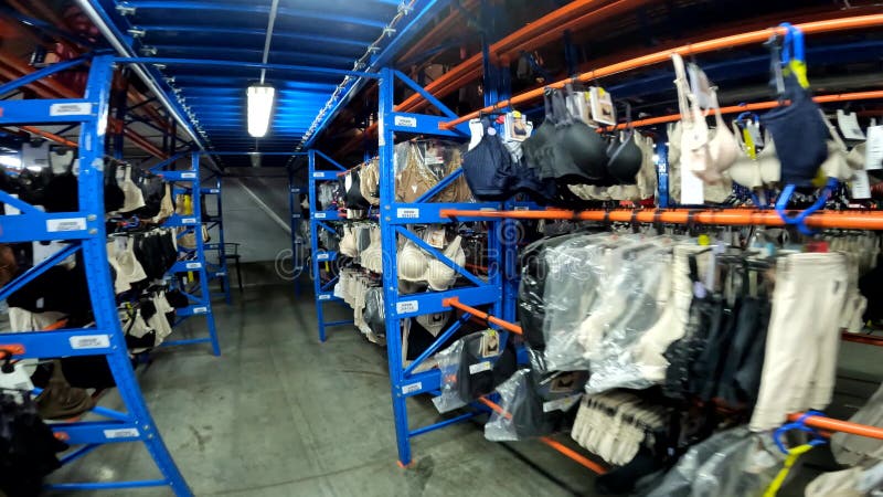 Clothes in the Warehouse of the Factory. the Clothes are Hung in Rows ...