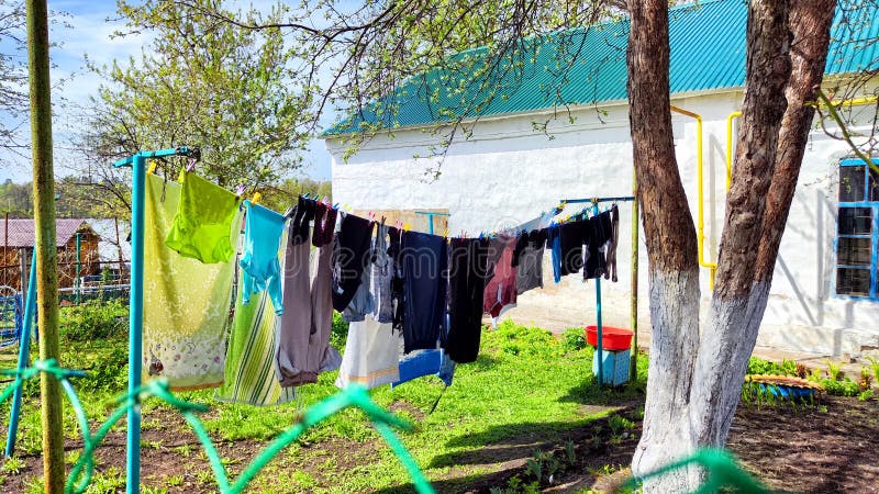 A Clothesline with Colorful Clothes Drying in a Rural Backyard Stock ...