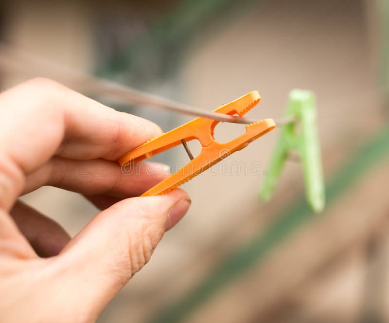 Clothespin in a Hand on a Clothesline Stock Image - Image of clothespin ...