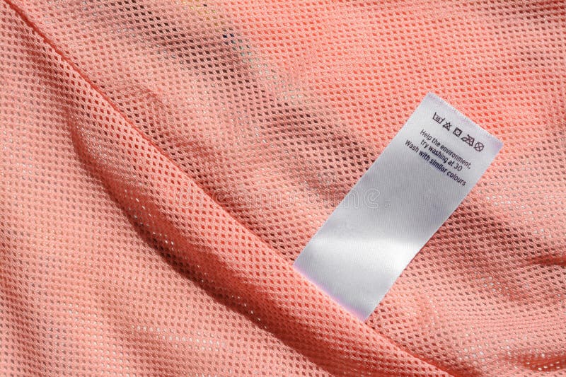Clothing Label with Instruction on Pink Garment, Closeup. Space for ...