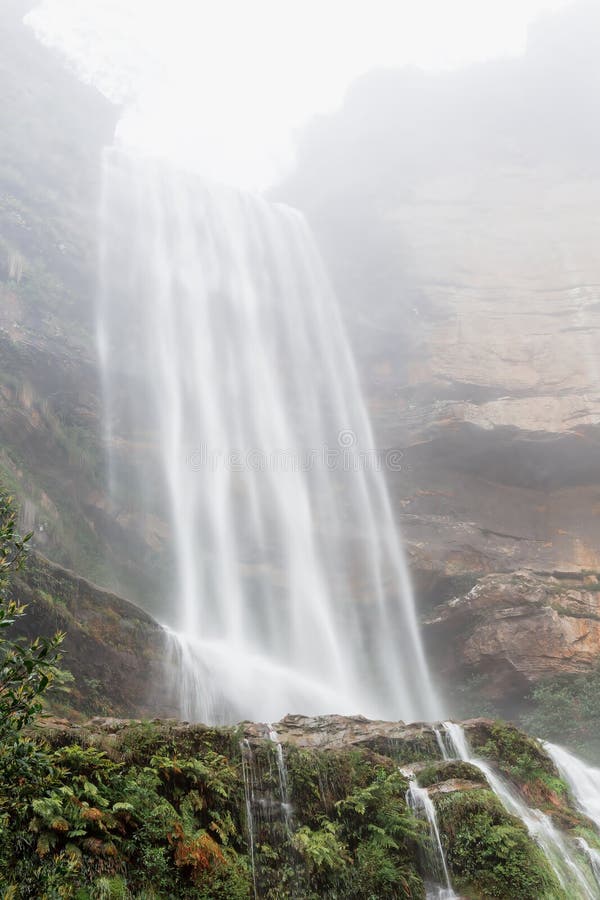 Cloud Mist and Full Flowing Waterfall Flowing Off a High Cliff Stock ...