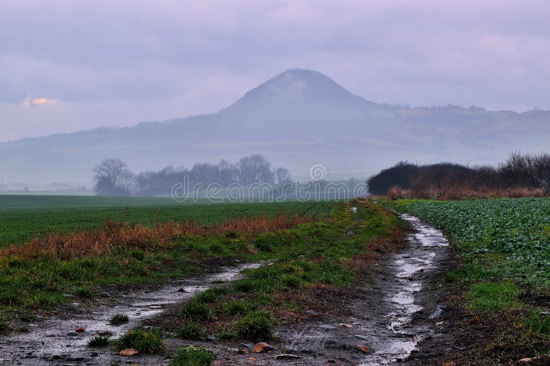 Clouds and Puddles after Rain on a Field Path through Misty Hills Stock ...