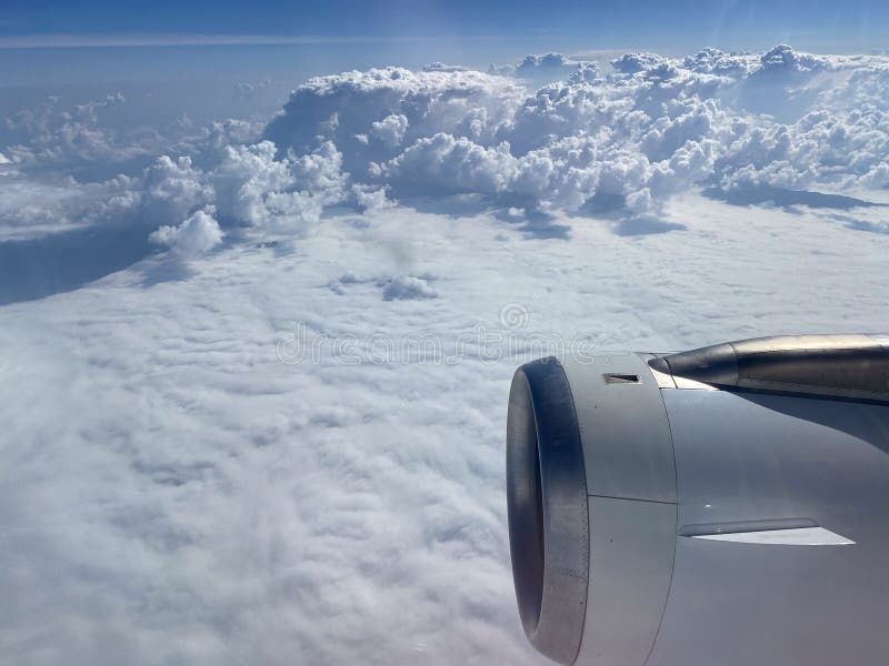 Cloudscape Viewed from Airplane Window with Engine in Foreground during ...
