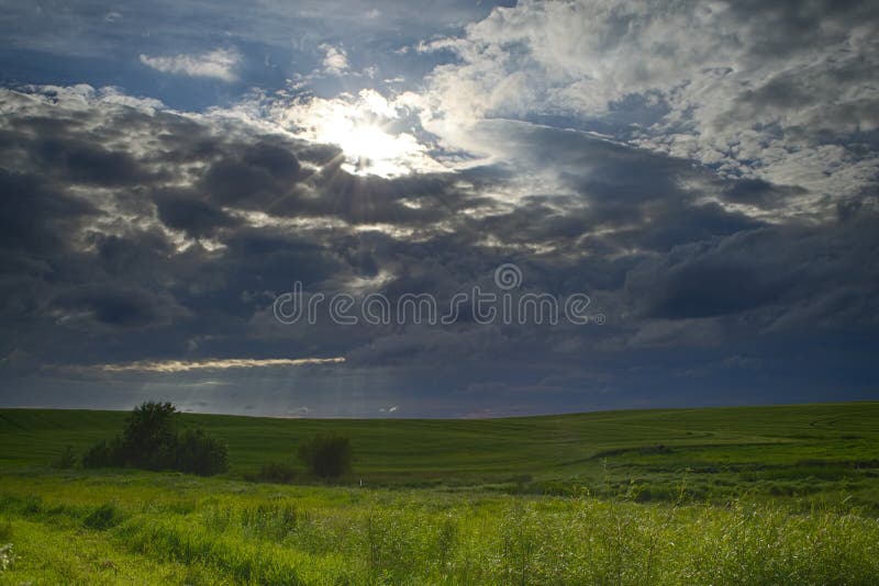 Cloudy Day with a Little Sun Shining Over Green Fields Stock Photo ...
