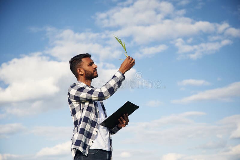 Standing and Holding Notepad. Handsome Indian Man is on the ...