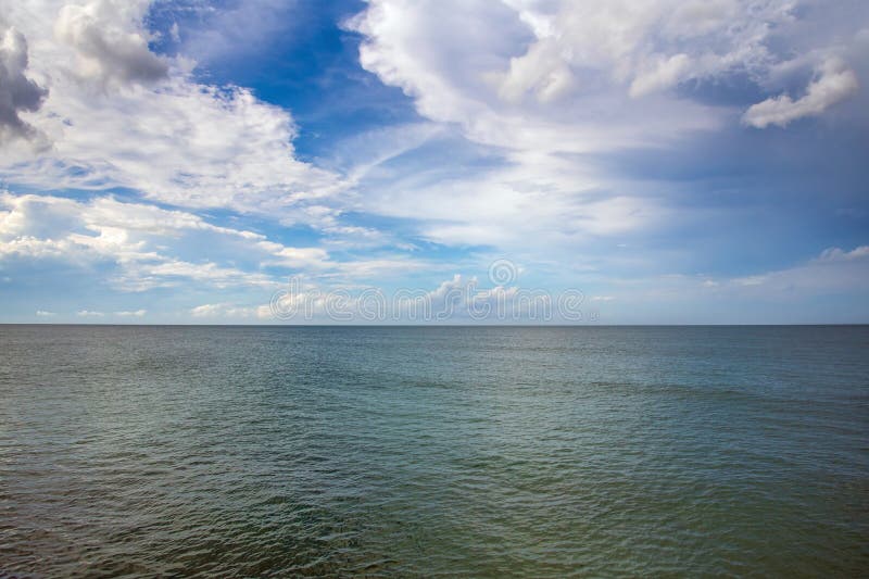 Cloudy sky meets the ocean stock photo. Image of smooth - 158561652
