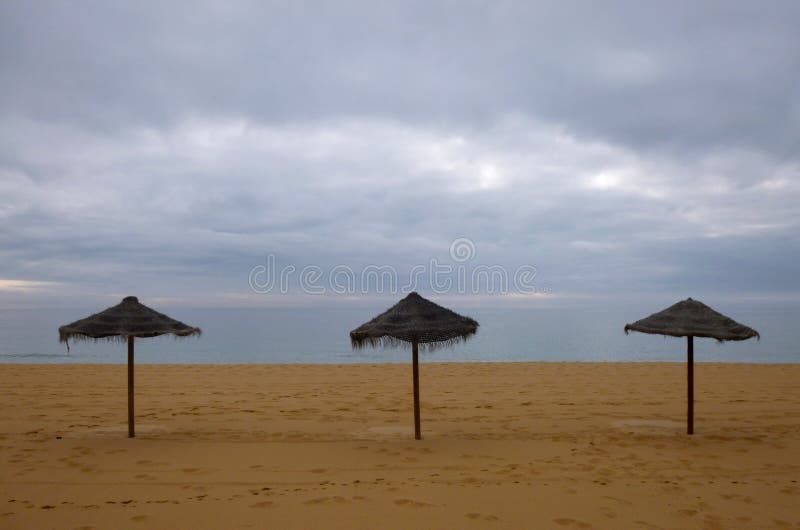 Three Bast Parasols on the Sandy Beach with Bad Weather Stock Image ...