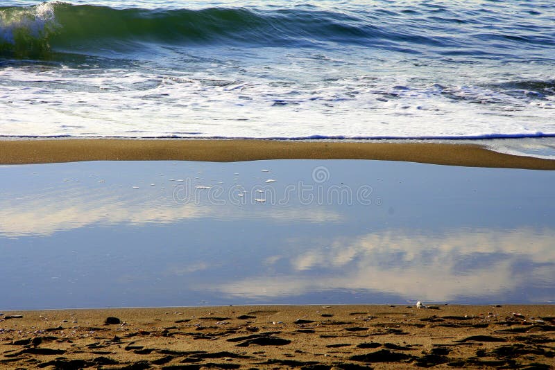 Cloudy Sky Reflection into Water Over the Beach Stock Photo - Image of ...
