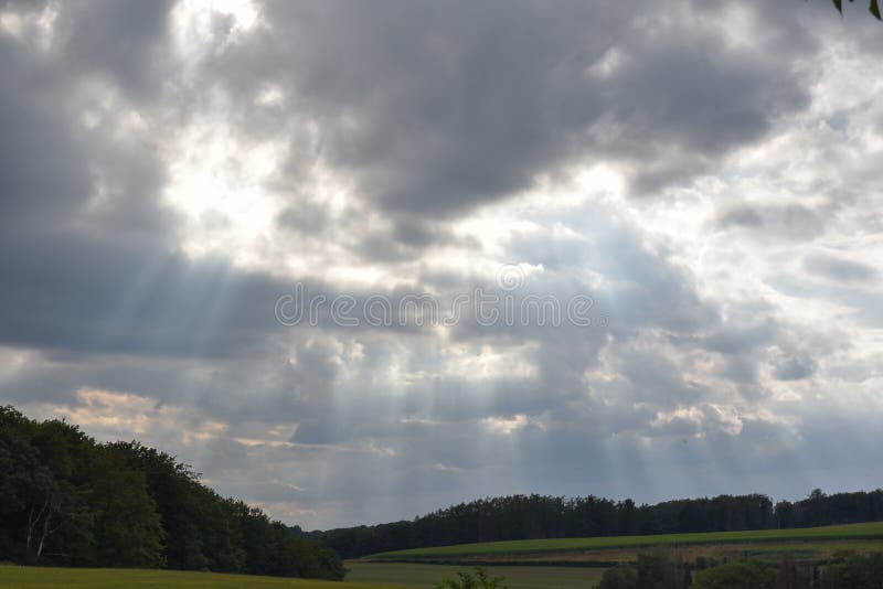 Cloudy Sky with Sunbeams Breaking through a Field Stock Photo - Image ...