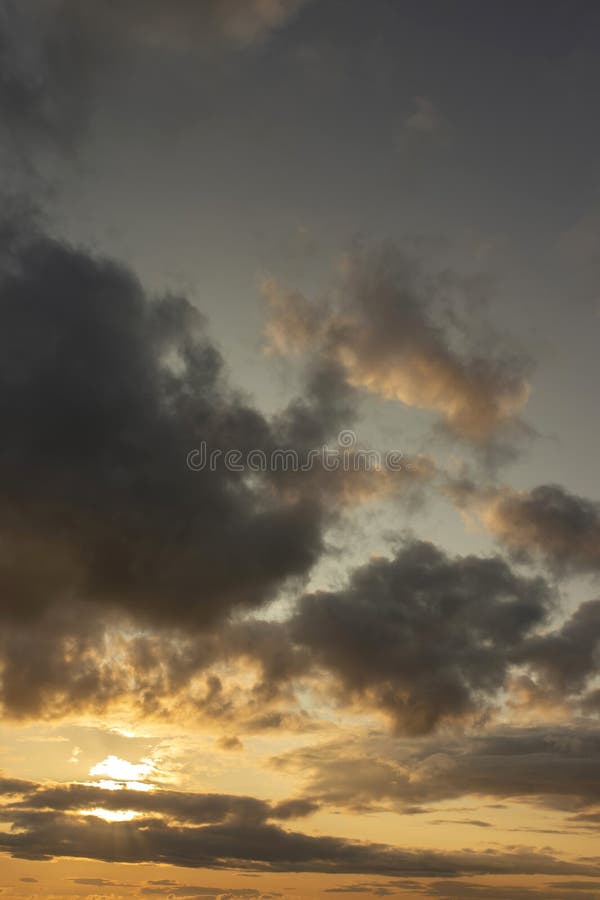 Cloudy Sunset Background with the Sun Rays Breaking through the Clouds Stock Photo - Image of ...