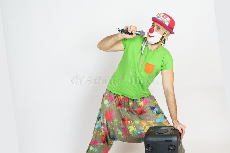 The Clown is Holding a Microphone, Singing. There is a Column Next To ...