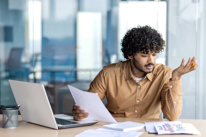 Clueless Diverse Male Checking Printed Documents on Desktop during ...