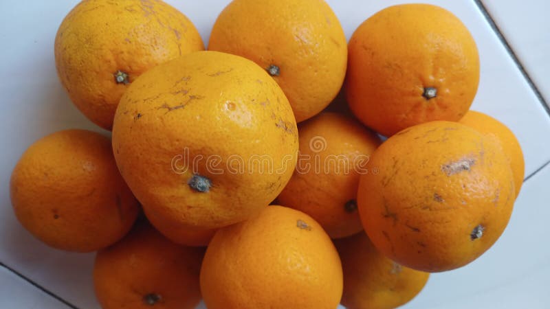 A Cluster of Fresh Oranges Displayed on a White Surface. the Oranges ...