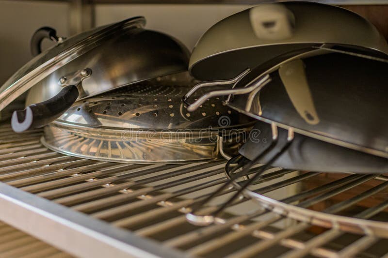 Cluttered Stacking Pots and Pans on a Cabinet Rack. Stock Photo - Image ...
