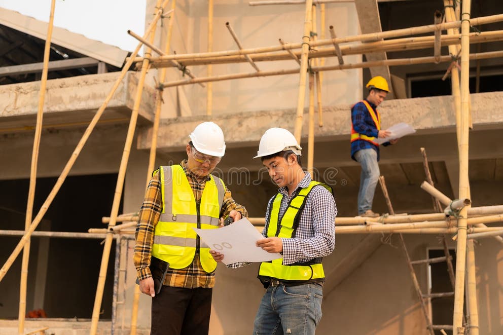 Co-workers Discussing Architecture Projects at Construction Site at ...