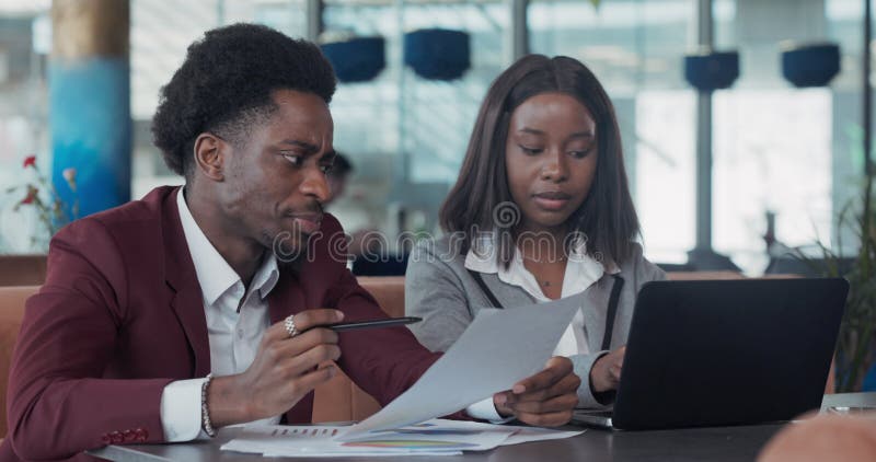 Co-workers Sit in a Restaurant and Work Together on a New Project for a ...