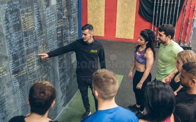 Coach Explaining To Athletes in the Gym Stock Photo - Image of overhead ...