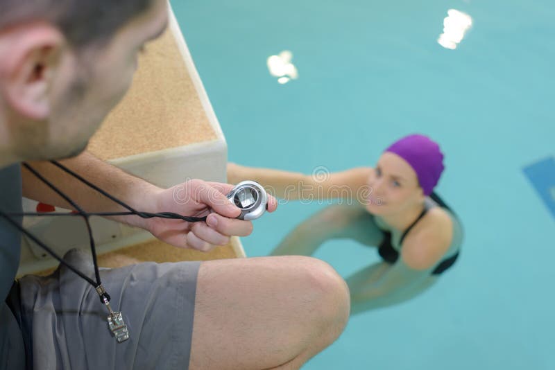 Coach Holding Stopwatch Against Fit Swimmer D Stock Image - Image of ...