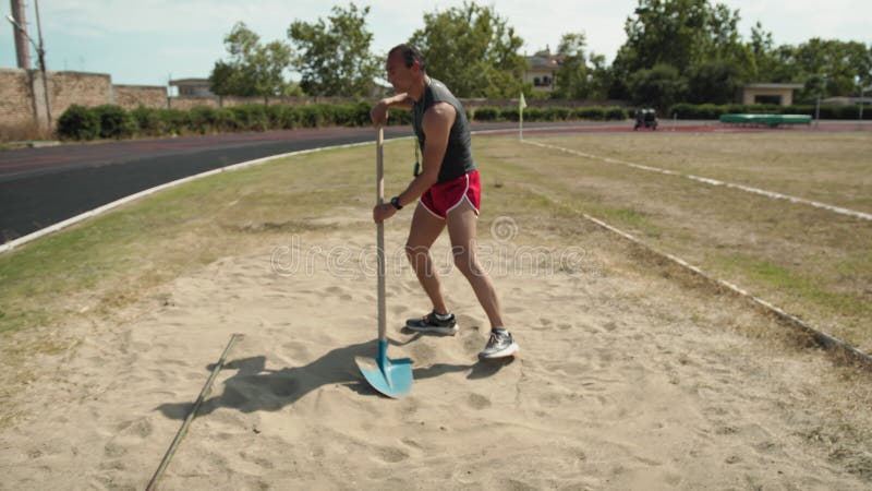 Coach Levelling the Sand for Long Jump Training Stock Footage - Video ...