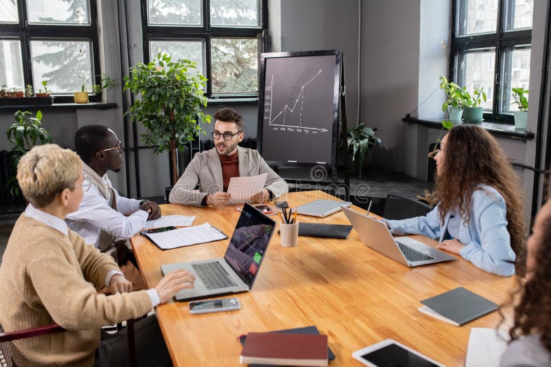 Coach with Paper Sitting by Table in Front of Managers Stock Image ...