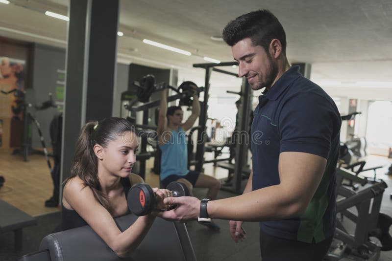 Coach Training Young Woman Lifting Weights at Gym Stock Photo - Image ...