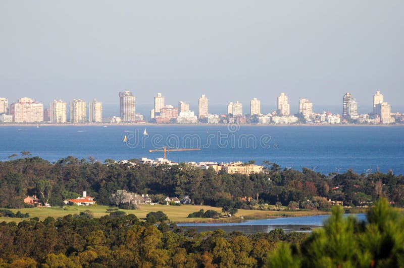 Coastal City Skyline with Ocean and Forest Under Clear Sky Stock Photo ...