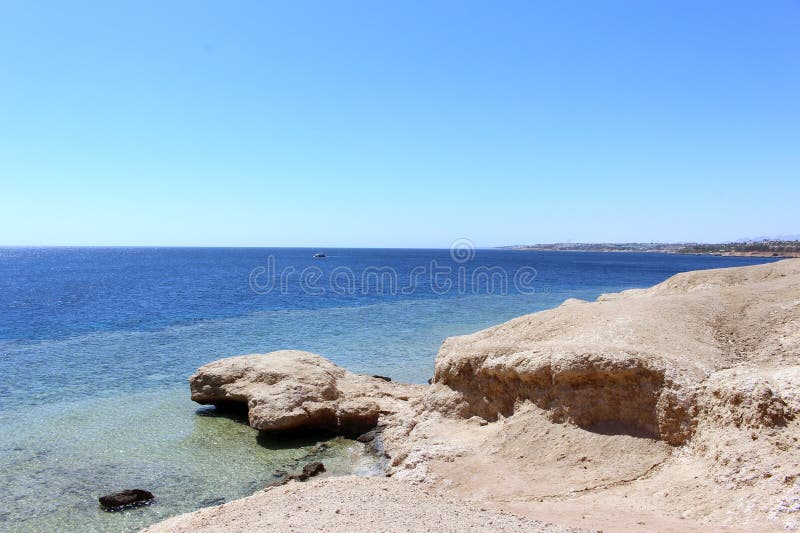 Coastal Cliff Landscape with Sandy Rocks and Deep Blue Ocean Under a ...