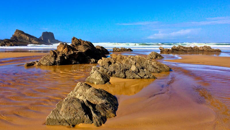 Coastal Landscape Featuring a Serene Beach, Scattered Rocks, and ...