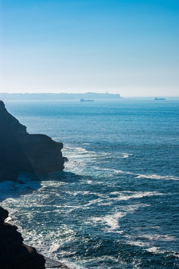 Coastline Cut into the Ocean with Boats and Lighthouse Cabo Mayor Stock ...