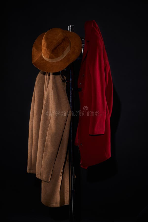 Coats and Hat Hanging on Coat Rack on Black Stock Image - Image of ...