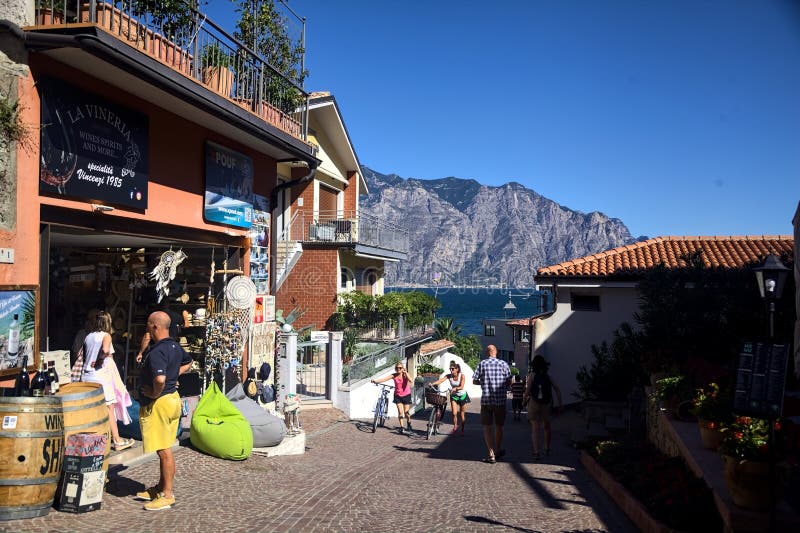 Cobbled Street with Shops at Its Corner and Lake Garda in the ...