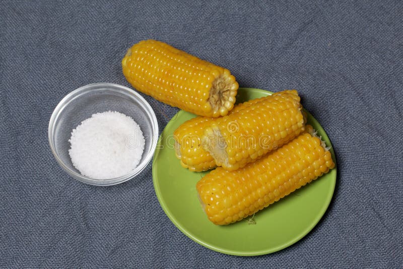 Cobs of Boiled Corn and Salt in a Salt Shaker. Against the Background ...