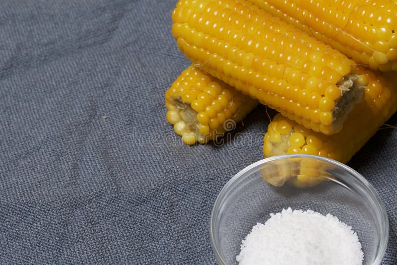 Cobs of Boiled Corn and Salt in a Salt Shaker. Against the Background ...