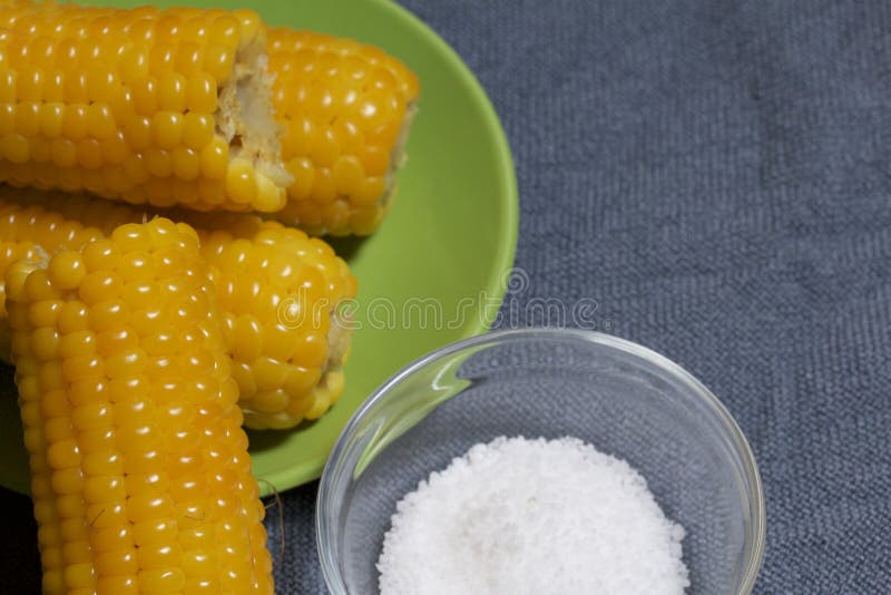 Cobs of Boiled Corn and Salt in a Salt Shaker. Against the Background ...