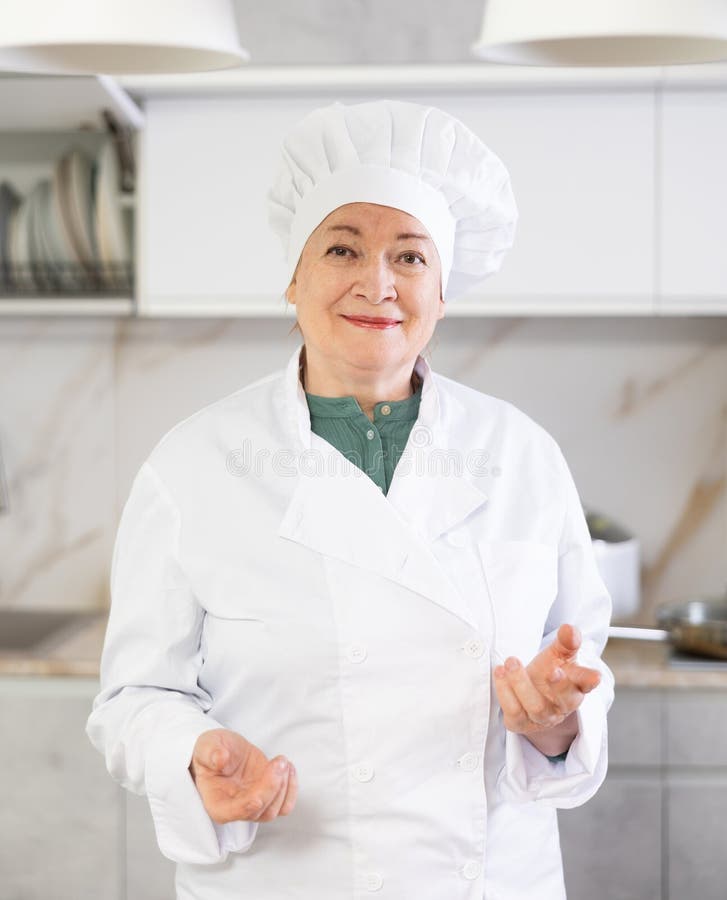 Cocinera Adulta Feliz Con Uniforme De Pie Y Mostrando Su Cocina Foto de ... Cocinera Adulta Feliz Con Uniforme De Pie Y Mostrando Su Cocina Foto de ...