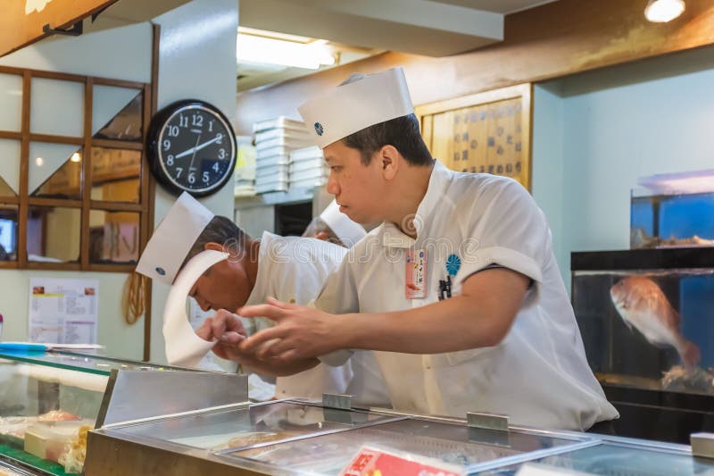 Cocinero Japonés Que Hace El Sushi De Color Salmón Foto de archivo ...