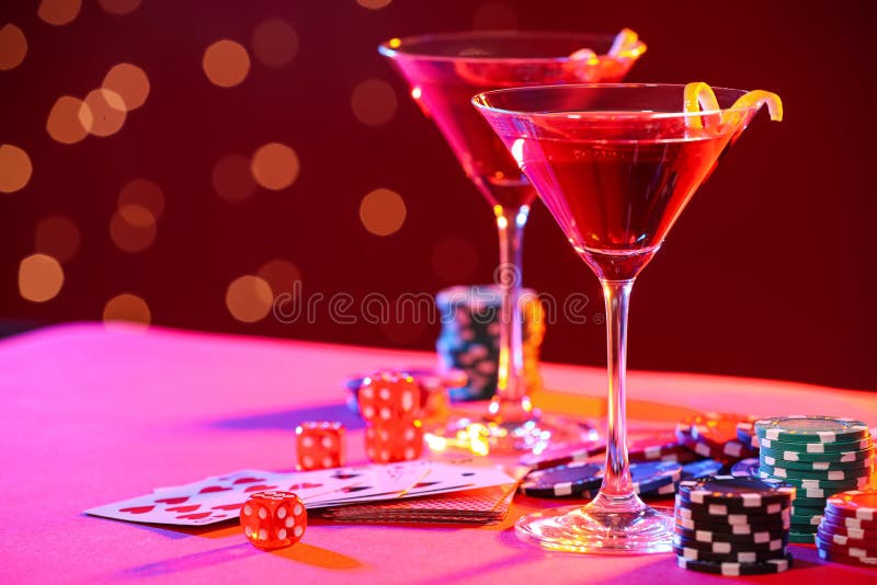 Cocktail, Dice, Playing Cards and Casino Chips on Table Against Blurred ...